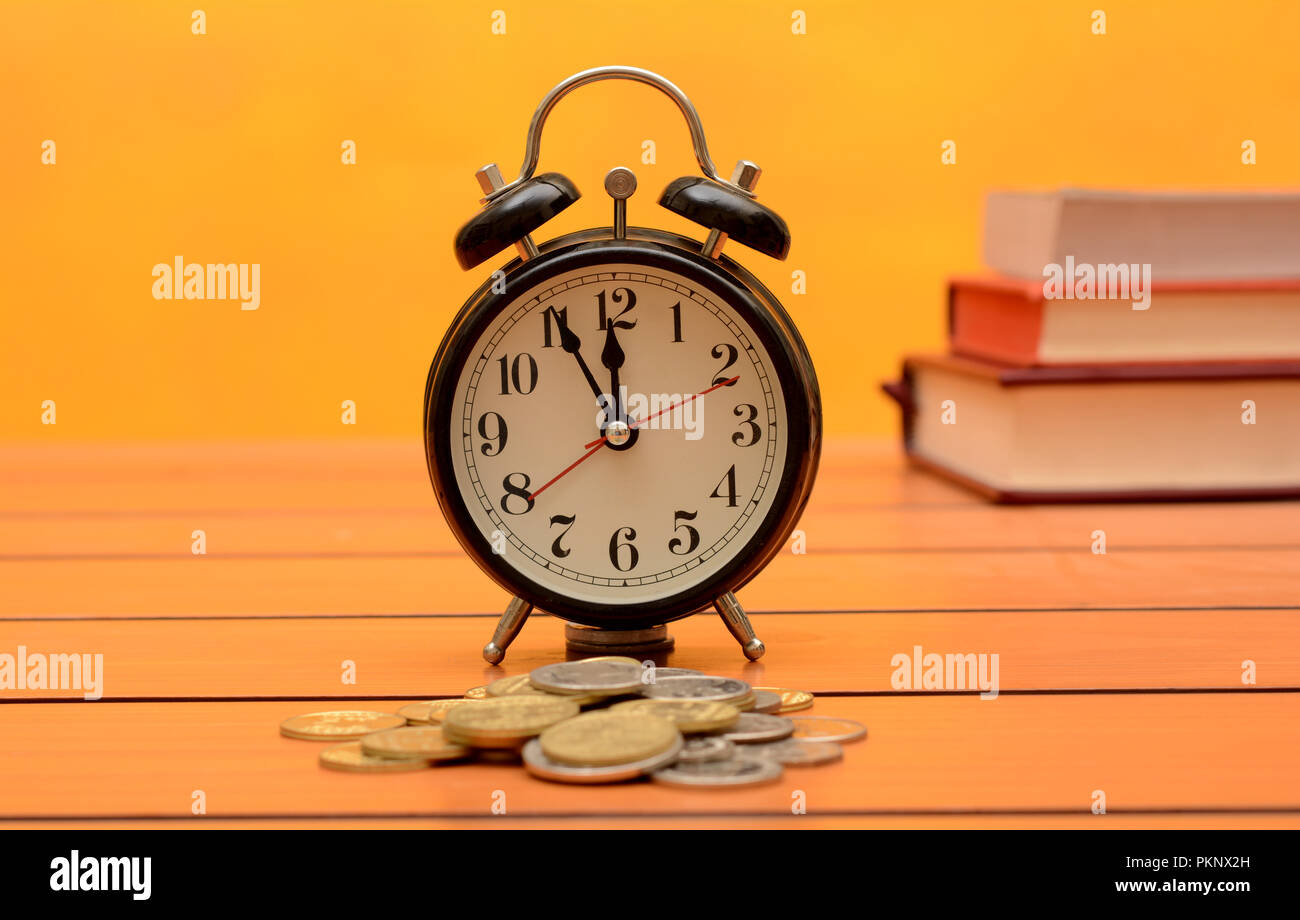 Time is money conceptual photo with clock and coins Stock Photo - Alamy