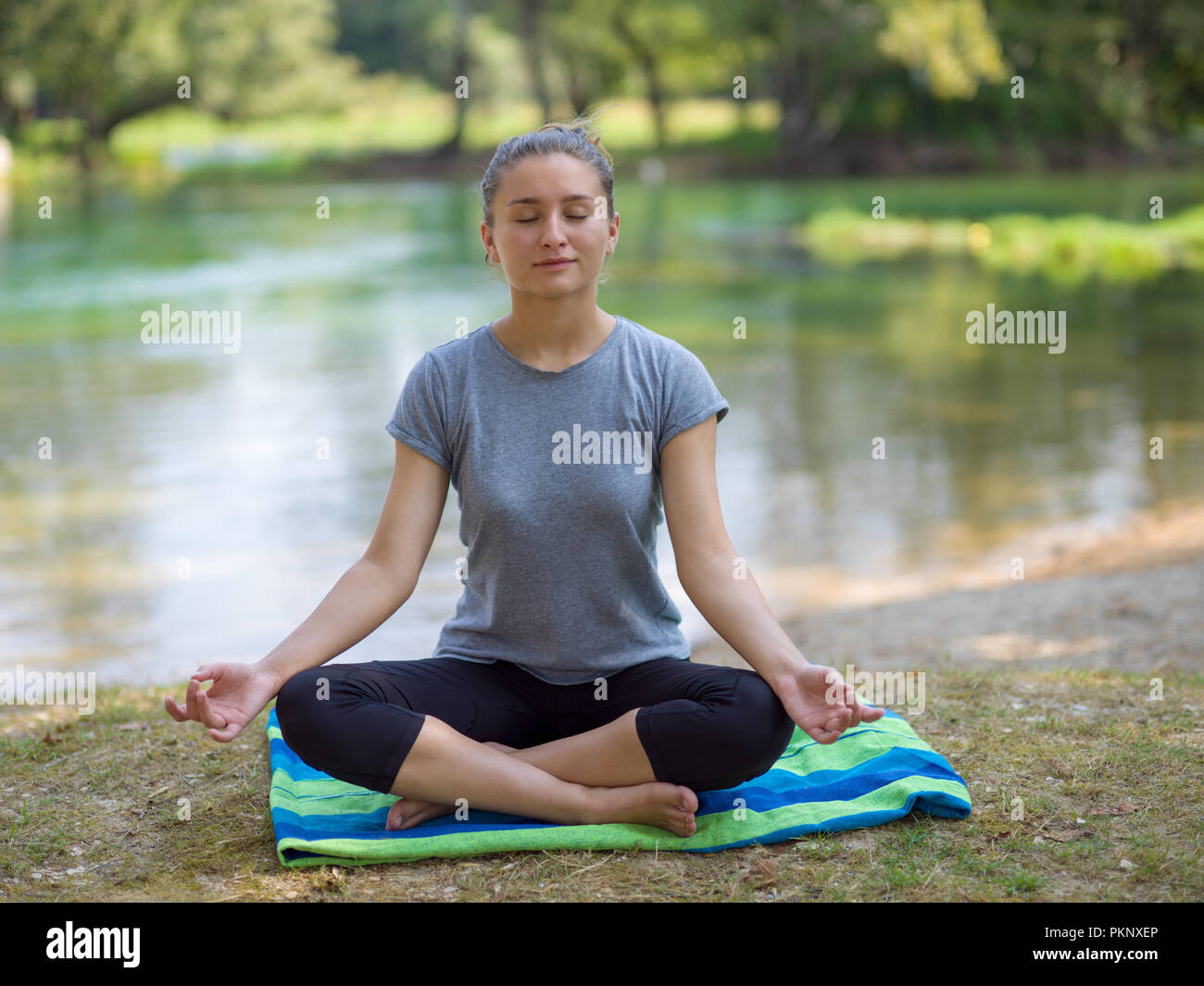 healthy woman relaxing while meditating and doing yoga exercise in the ...