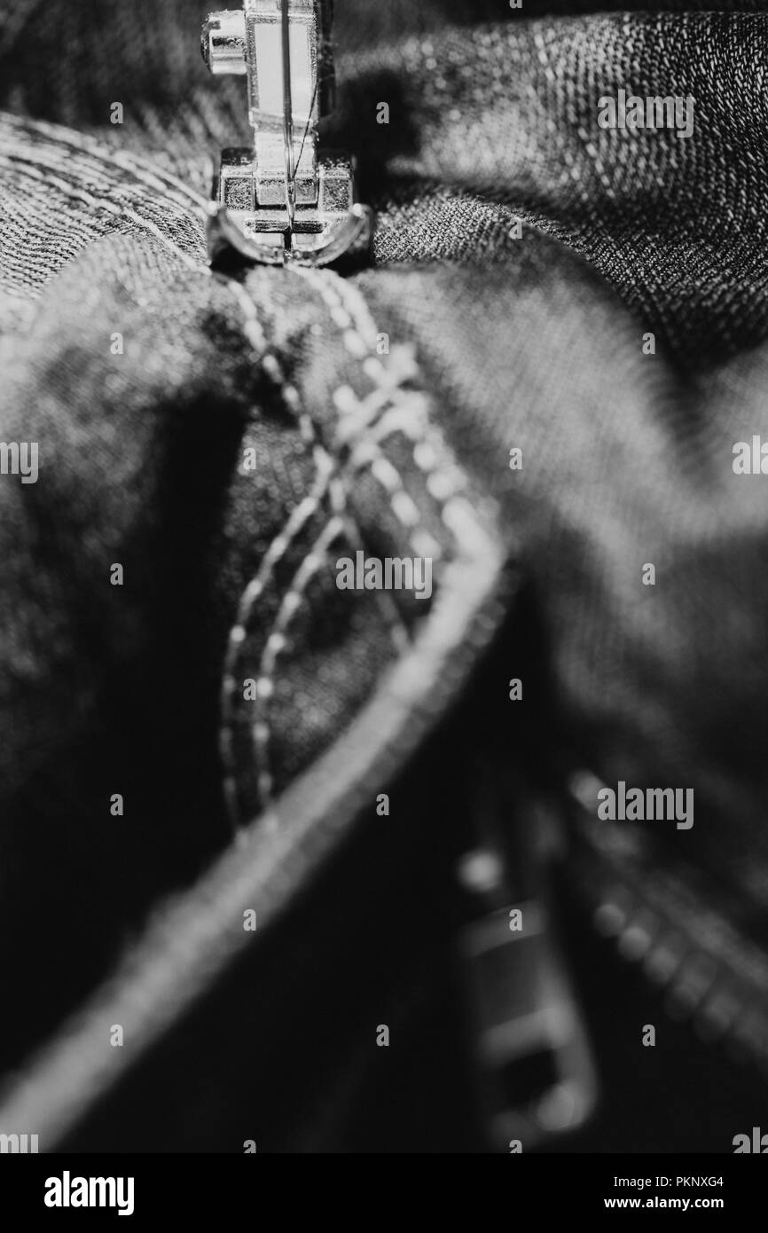 Repair jeans on the sewing machine. View of the fabric, needle and ...