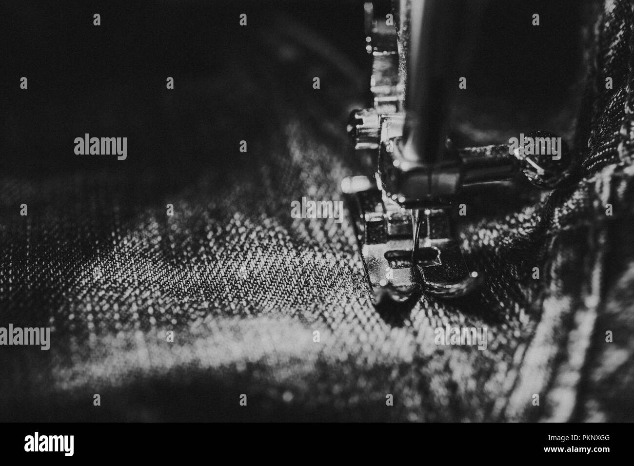 Repair jeans on the sewing machine. View of the fabric, needle and ...