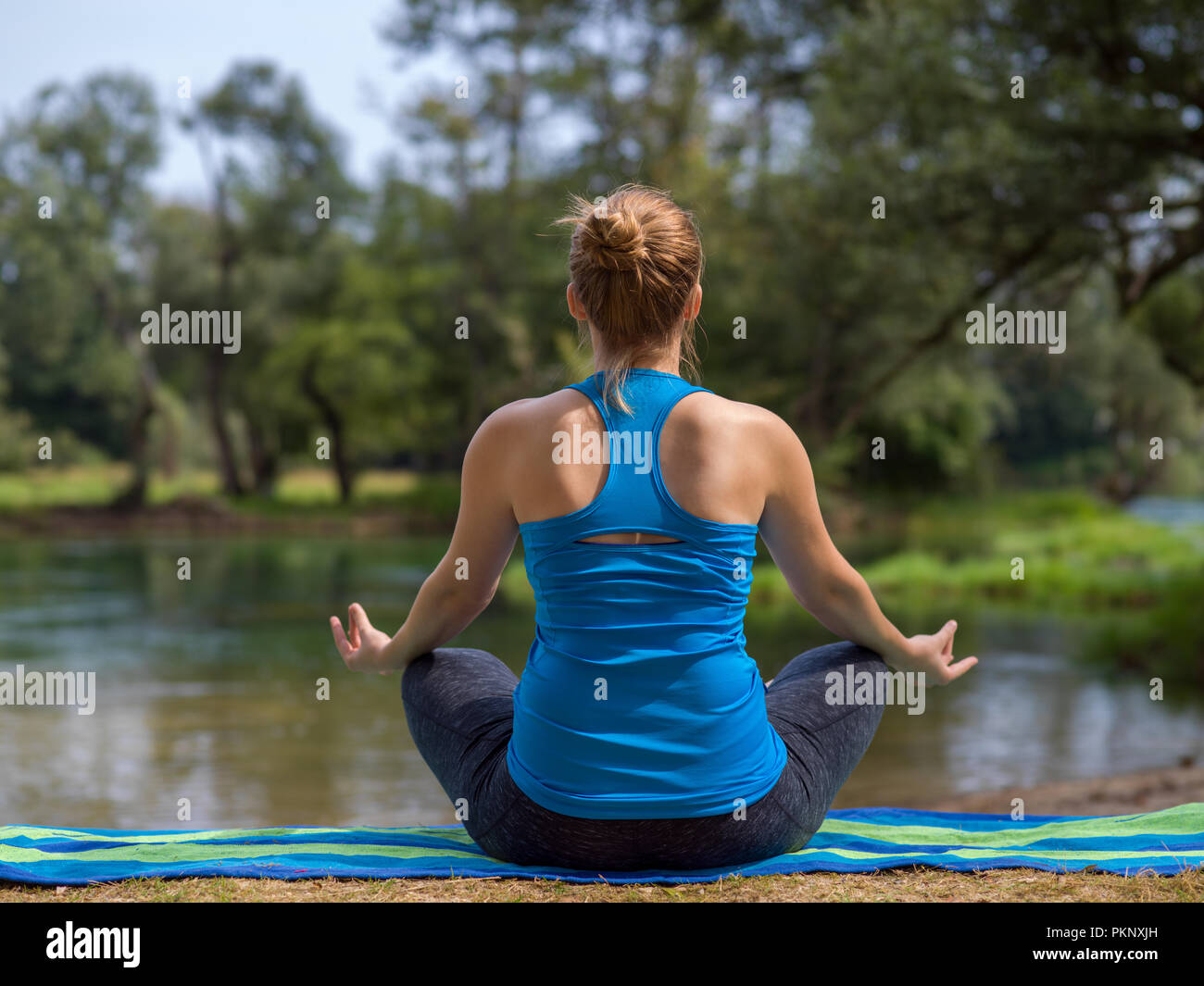 healthy woman relaxing while meditating and doing yoga exercise in the ...