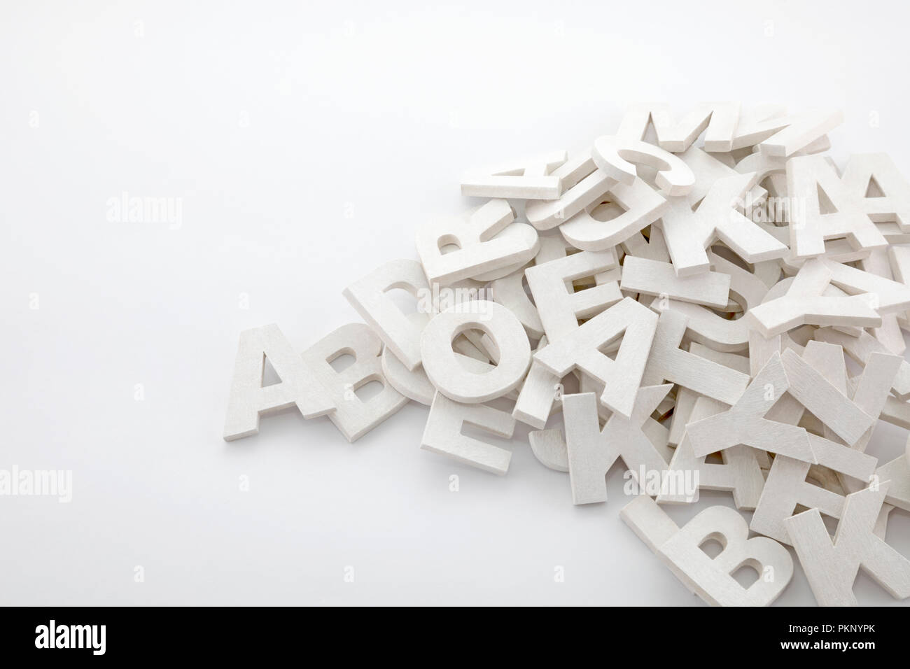Pile of white painted wooden letters. Typography background composition ...