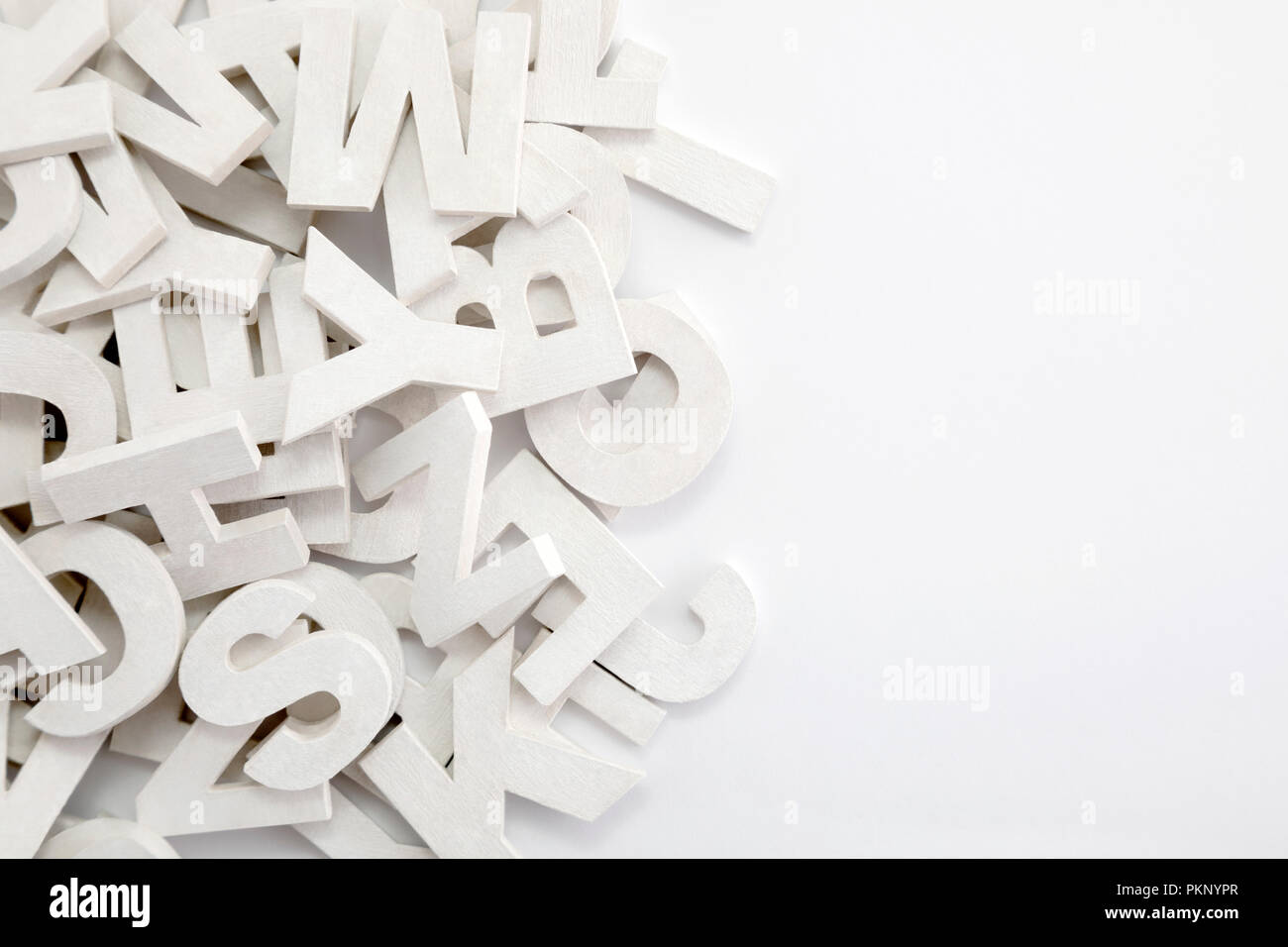 Pile of white painted wooden letters. Typography background composition ...