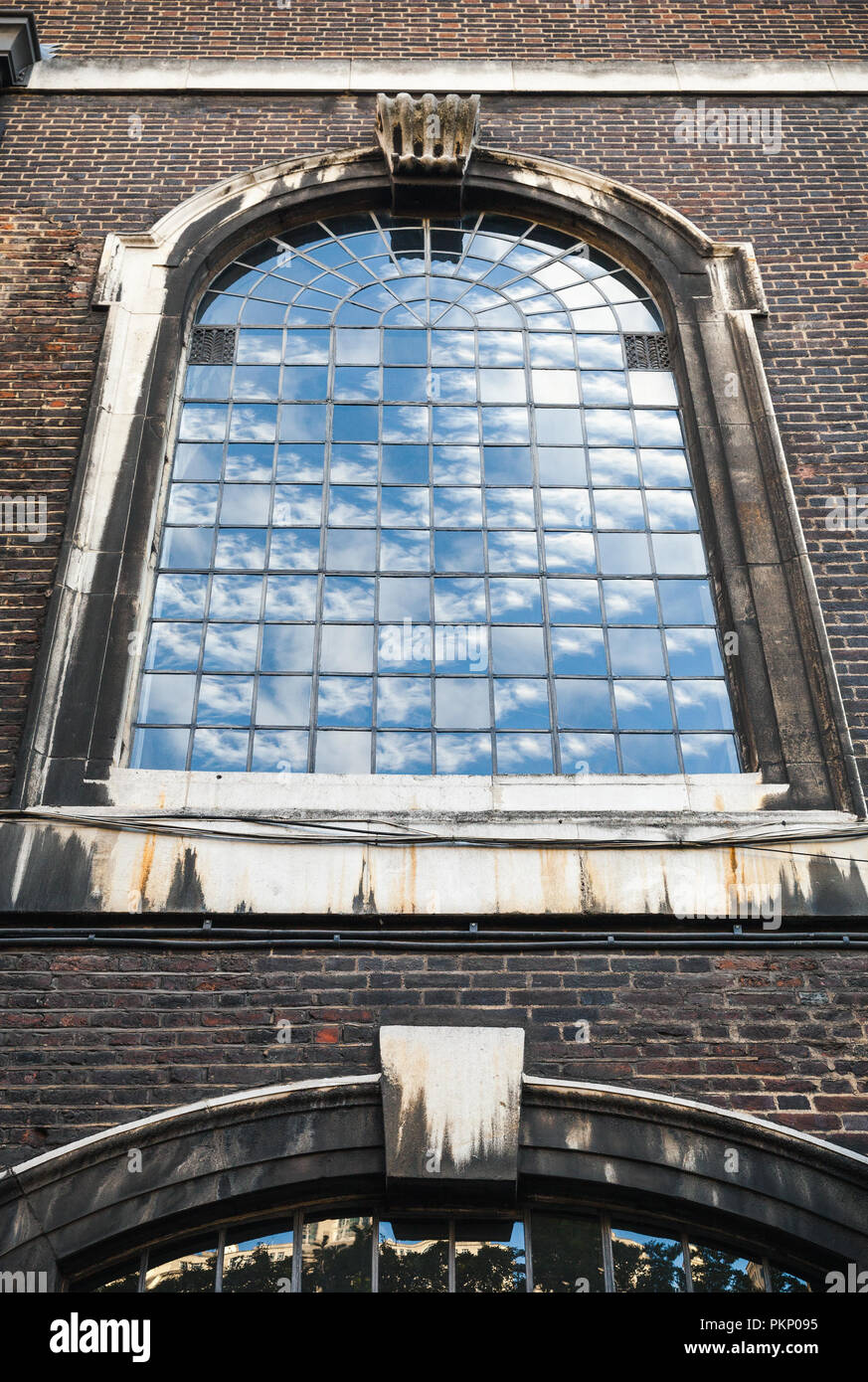 Old classic arched window perspective in dark brick wall, London ...