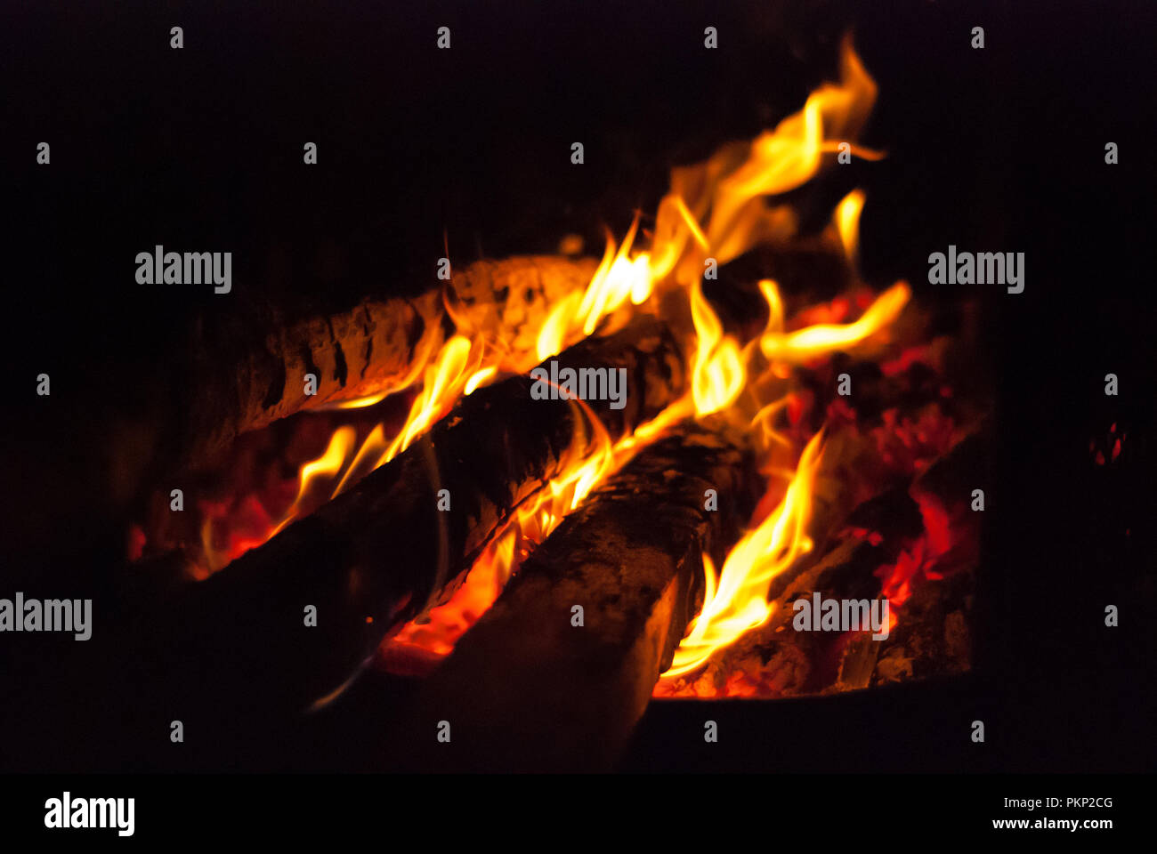burning logs of a campfire against a black background Stock Photo - Alamy