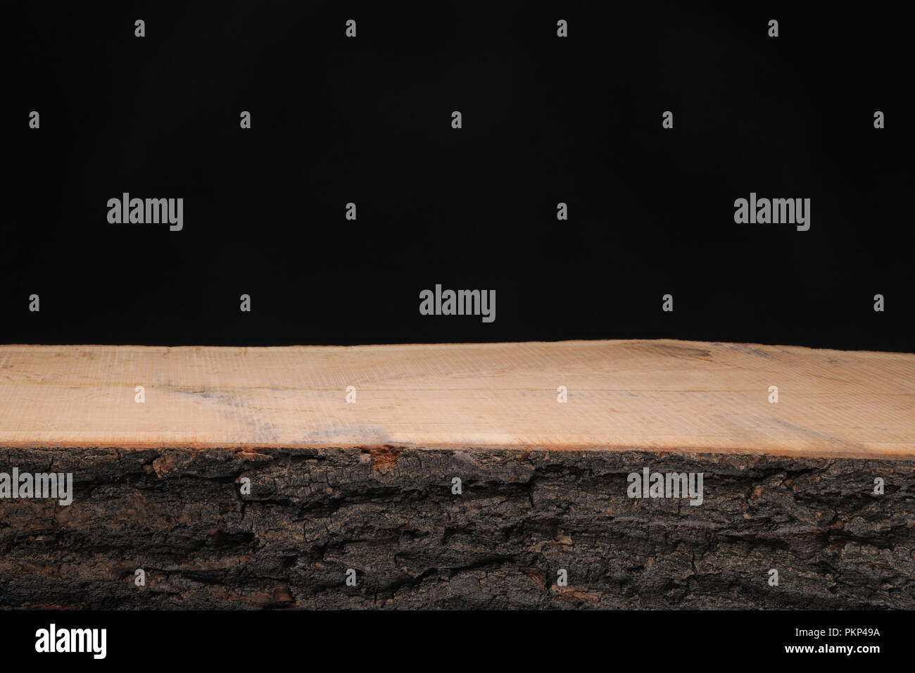 sawn along a tree log with bark on a black background Stock Photo - Alamy
