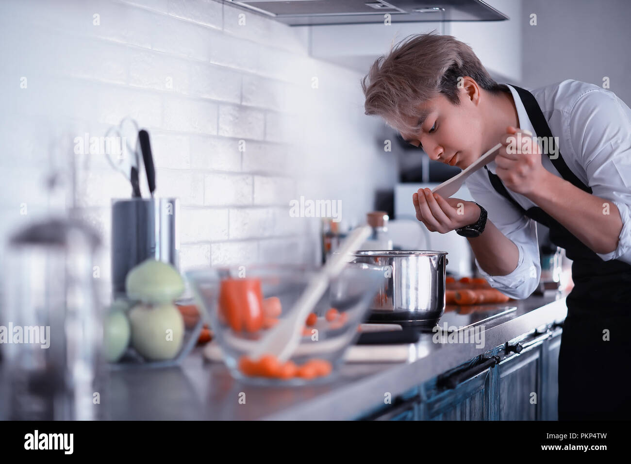 Asian cook in the kitchen prepares food in a cook suit Stock Photo - Alamy