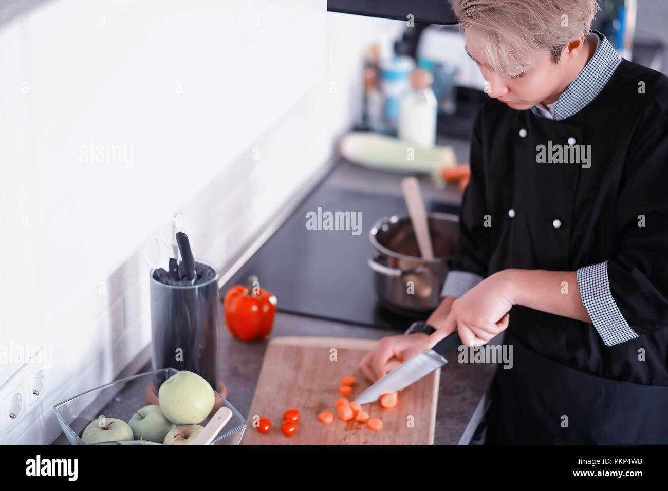 Asian cook in the kitchen prepares food in a cook suit Stock Photo - Alamy