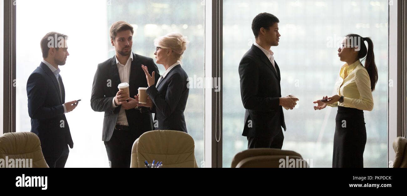 Multiracial, business people talking in break, standing near win Stock ...