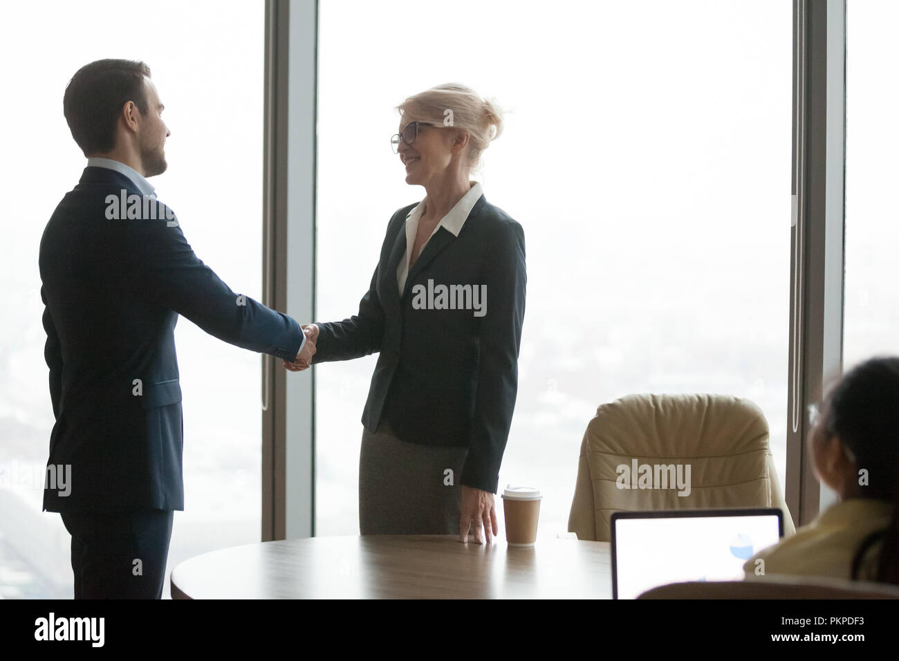 Older director ceo welcomes the new colleague Stock Photo - Alamy