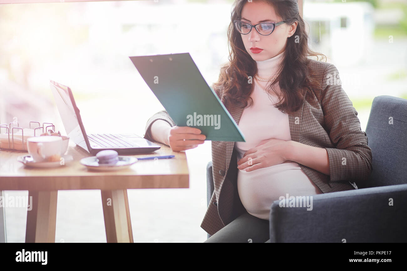Pregnant woman working on computer in cafe Stock Photo - Alamy