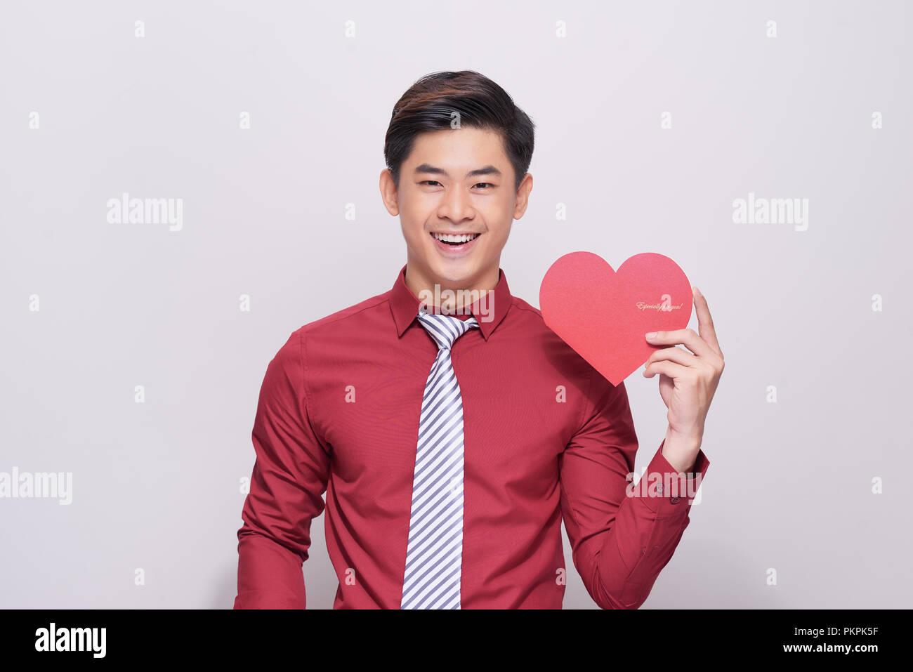 I love you! Handsome young man holding heart shaped valentine card and ...