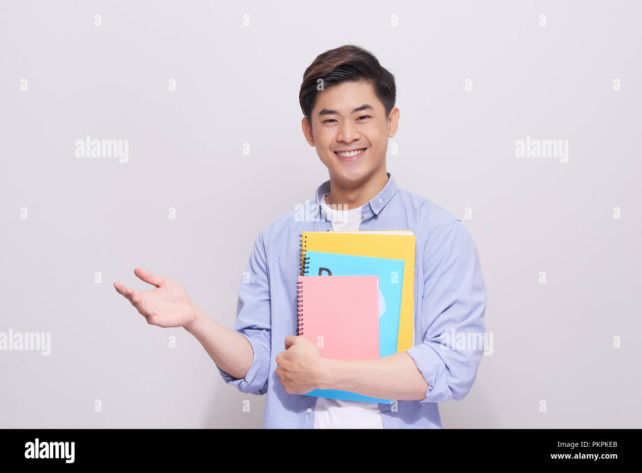 Confident asian handsome student holding books gesture hand Stock Photo ...
