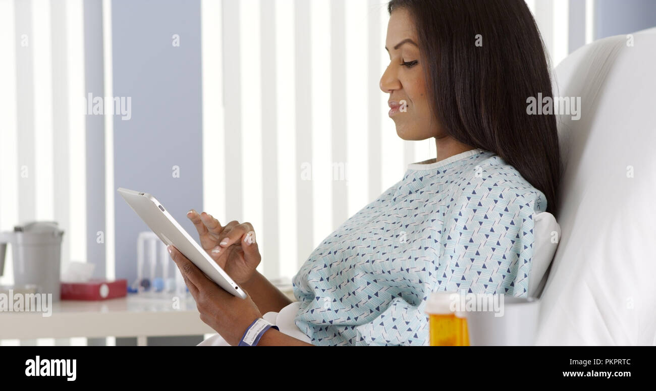 African American woman using tablet computer in hospital bed Stock ...