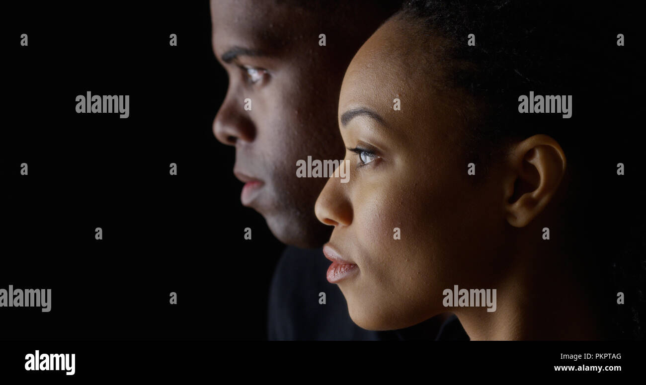 Dramatic side view of two young African American people on black ...