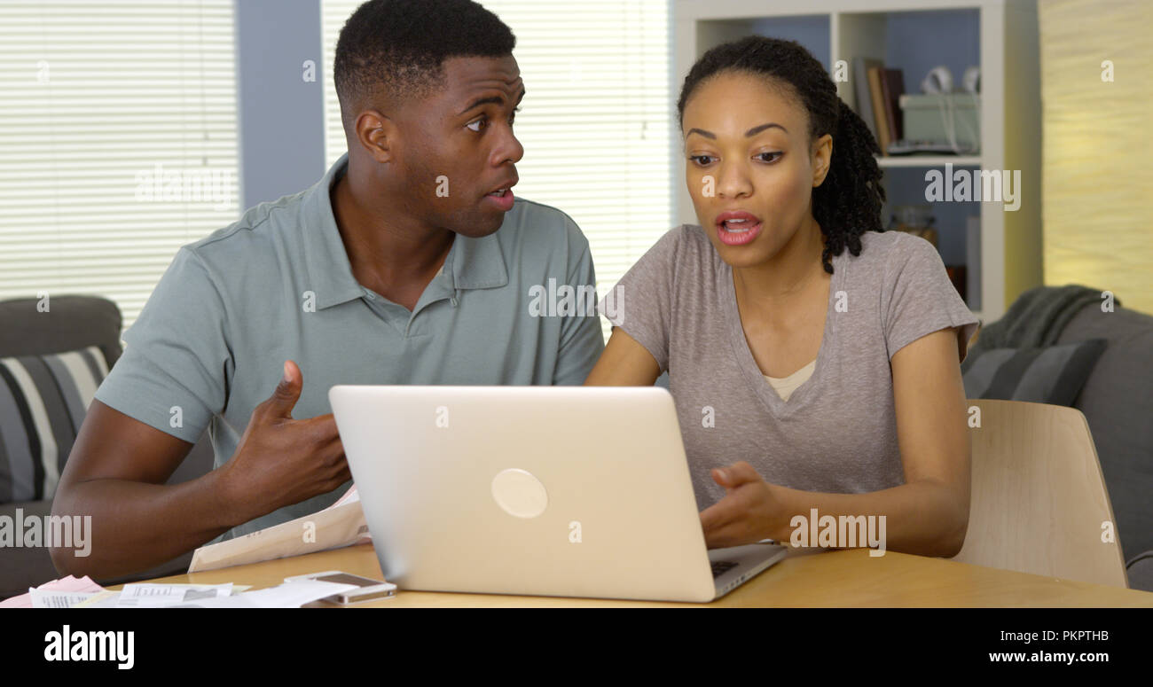 Upset young Black couple arguing over bills and finances with laptop ...