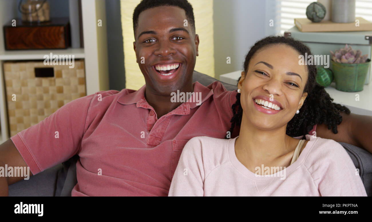 Young African American couple on couch talking to camera Stock Photo ...