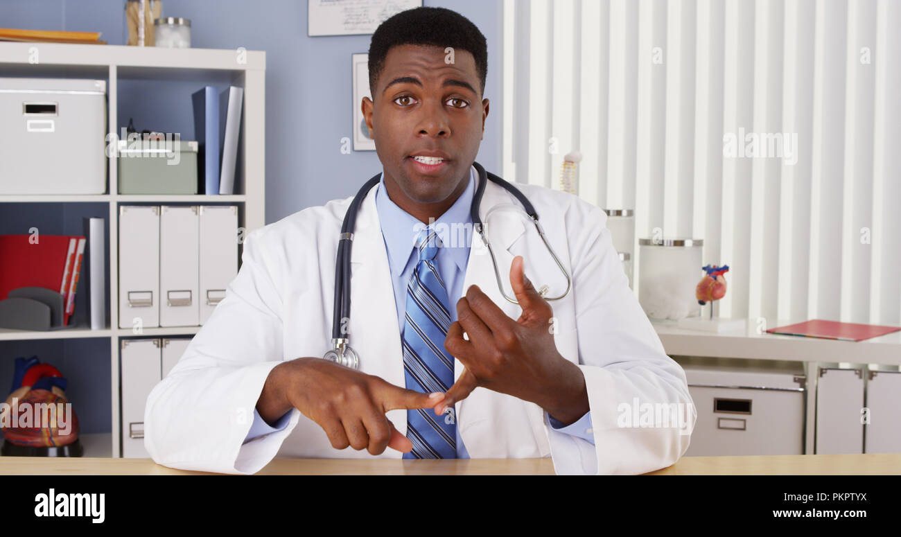 Black doctor talking to camera in video chat Stock Photo - Alamy
