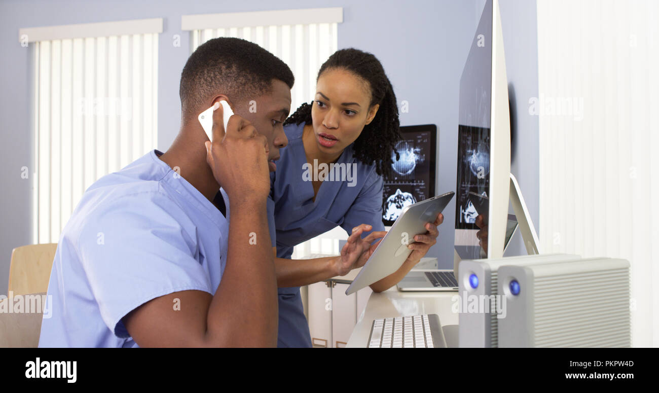 Two African American specialists working together in hospital work ...