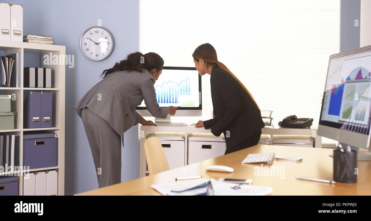 Multi-ethnic business colleagues going over charts over charts Stock ...