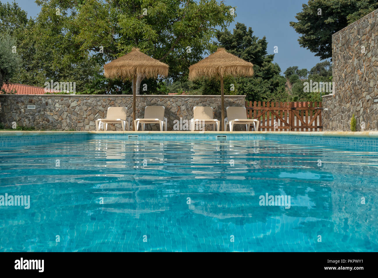 Pool view at the water level with leisure chair Stock Photo - Alamy