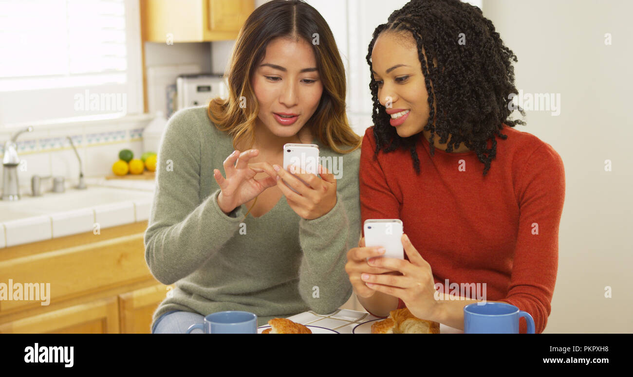 Two women best friends using smart phones and eating breakfast Stock ...