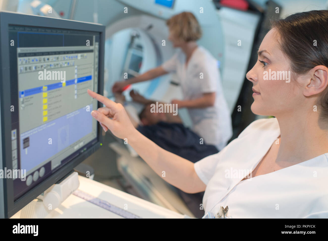 female doctor pushing control button on ct scanner Stock Photo - Alamy