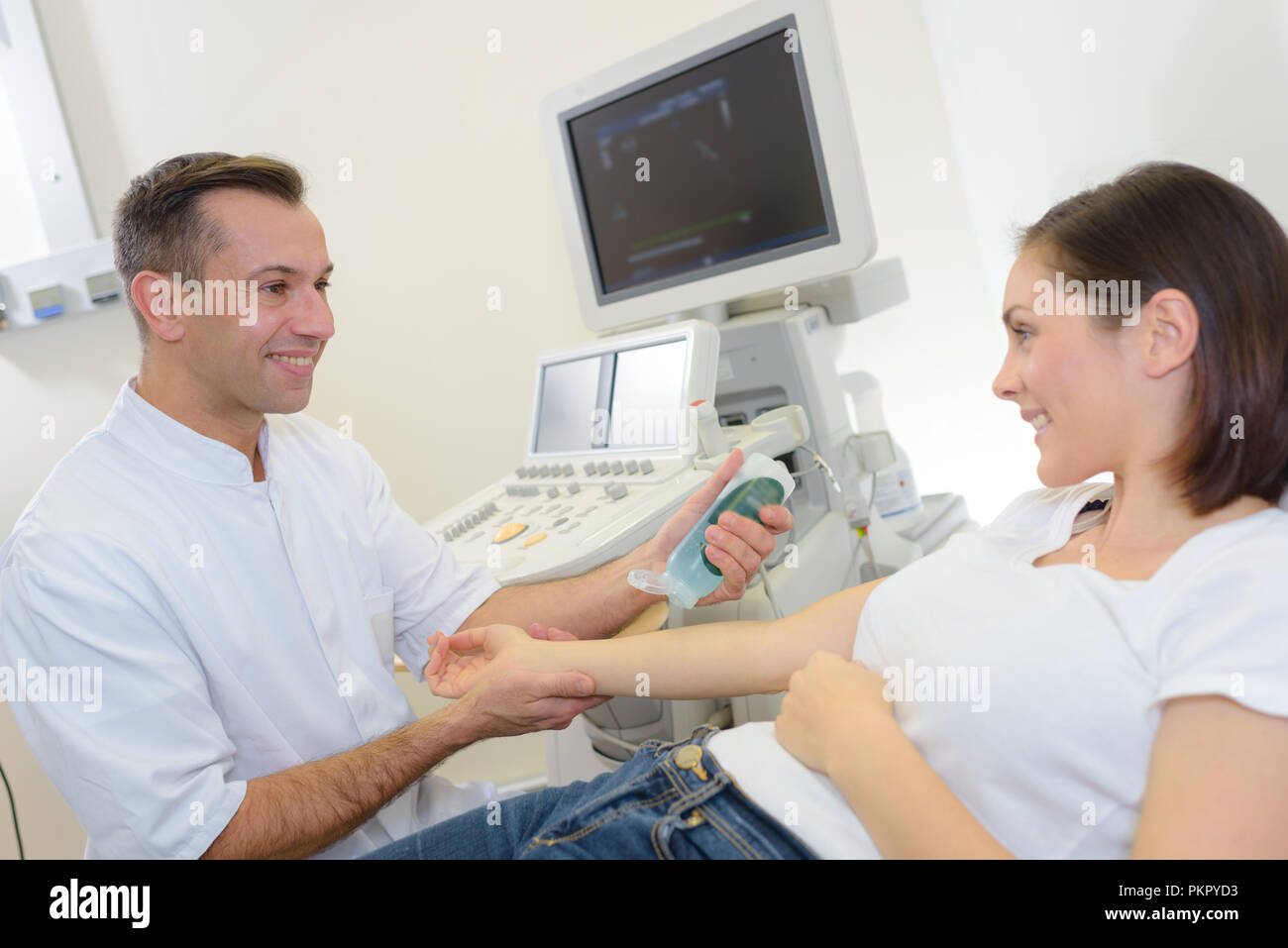 male doctor with female patient undergoing arm echography Stock Photo ...