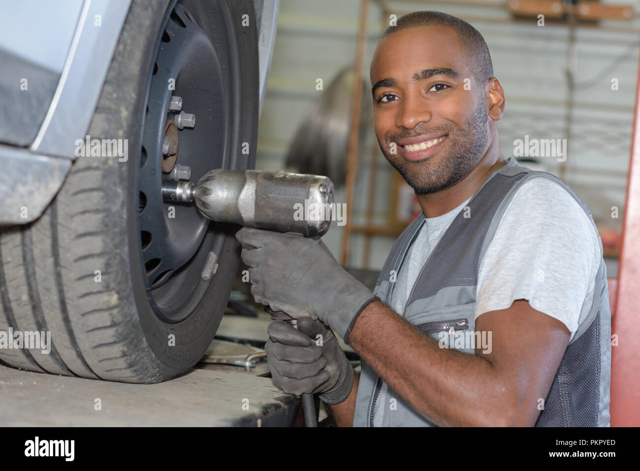 car mechanic screwing or unscrewing car wheel Stock Photo - Alamy