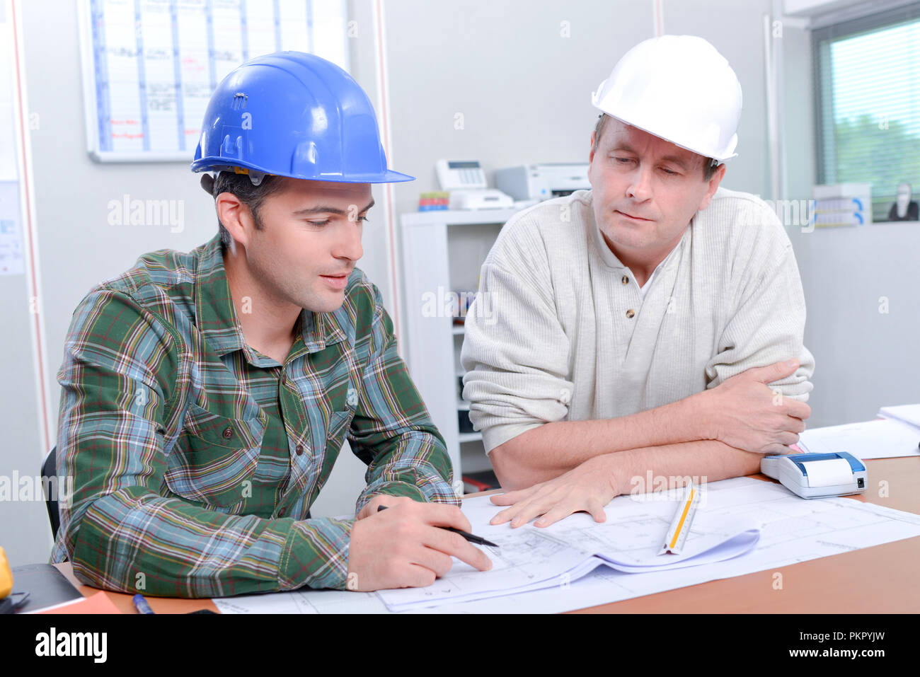 Two architect looking over plans Stock Photo - Alamy