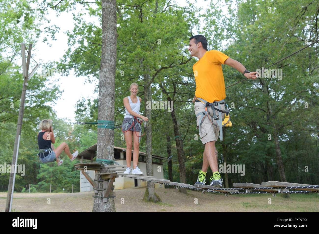 Adults crossing rope bridge Stock Photo - Alamy