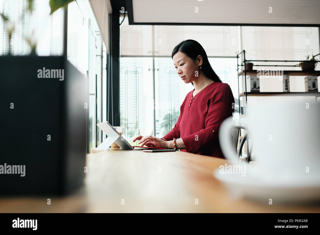 Portrait of happy Chinese female manager working in a bar outside the ...