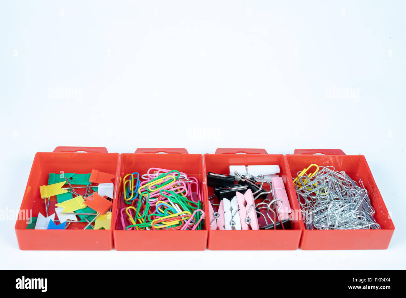 Office supplies on a white table. Paper clips and clips for office use ...
