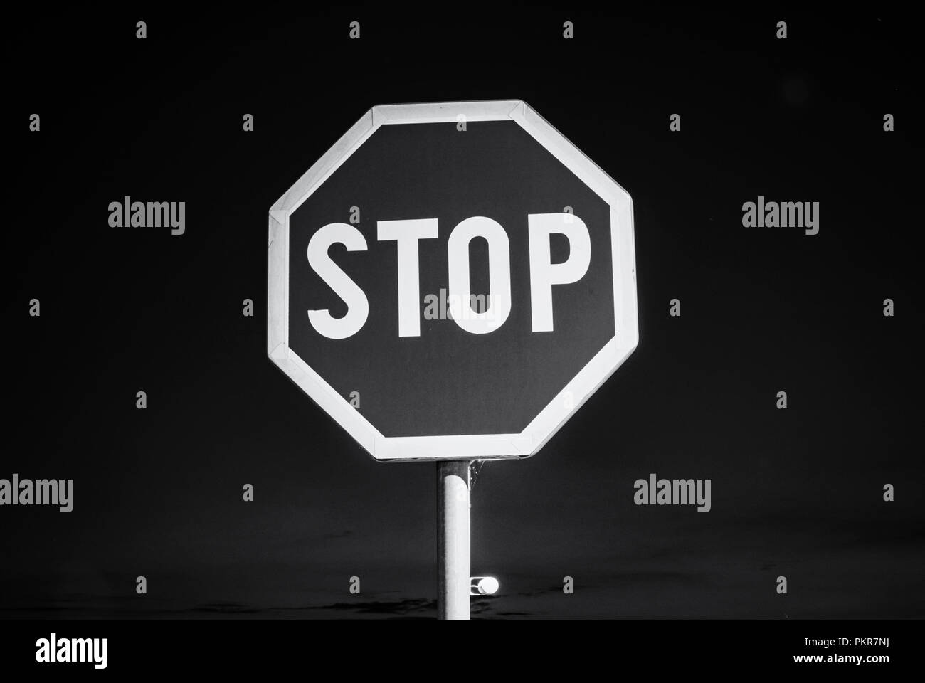 Stop sign in the night city. Traffic regulation. Black and white photo ...