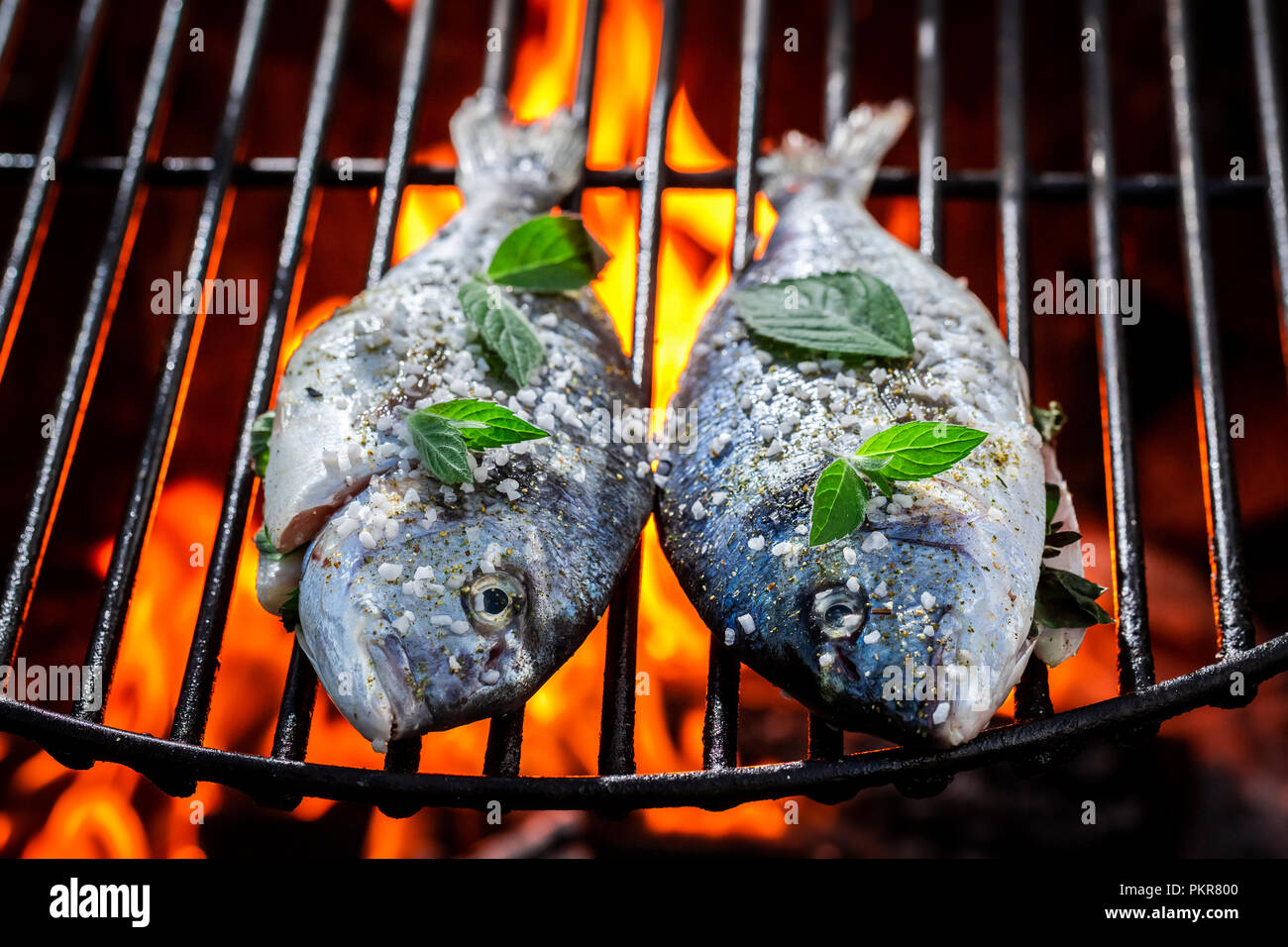 Spicy fish on grill with herbs and salt Stock Photo - Alamy