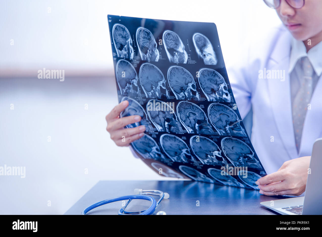 young female doctor holding MRI or CT scan picture, doctor in uniform ...