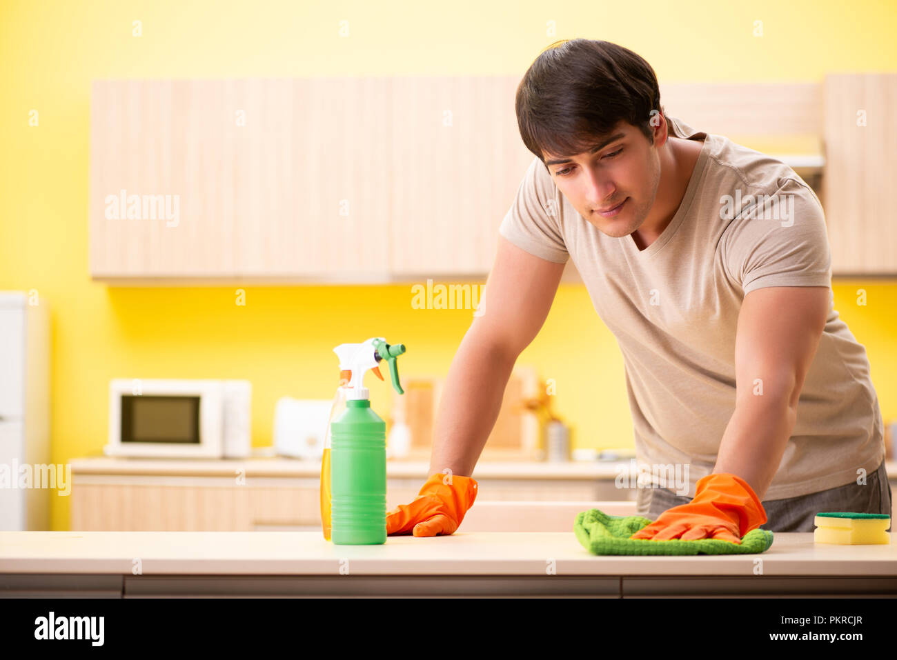 Single man cleaning kitchen at home Stock Photo - Alamy