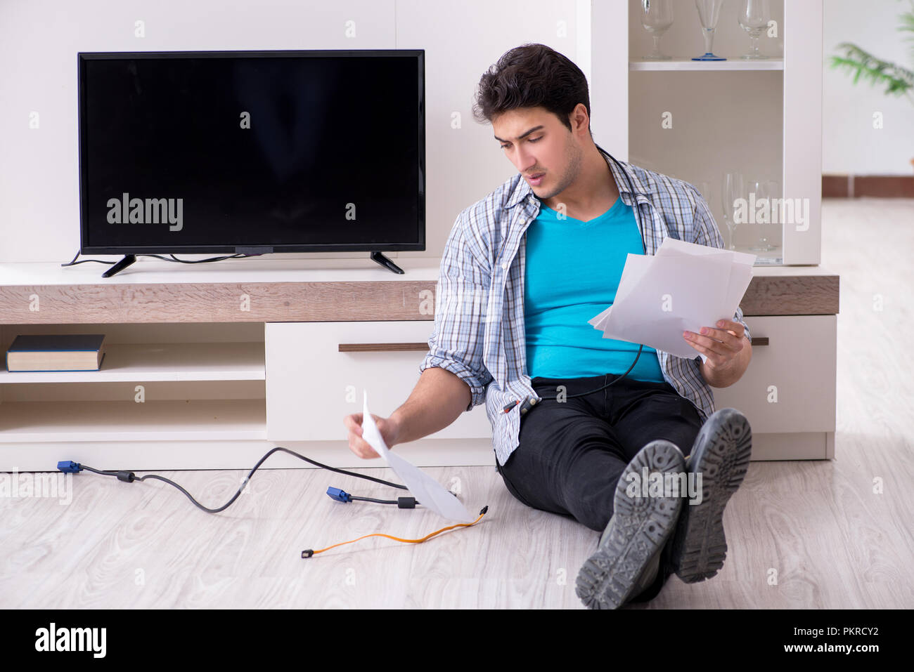 Man trying to fix broken tv Stock Photo - Alamy