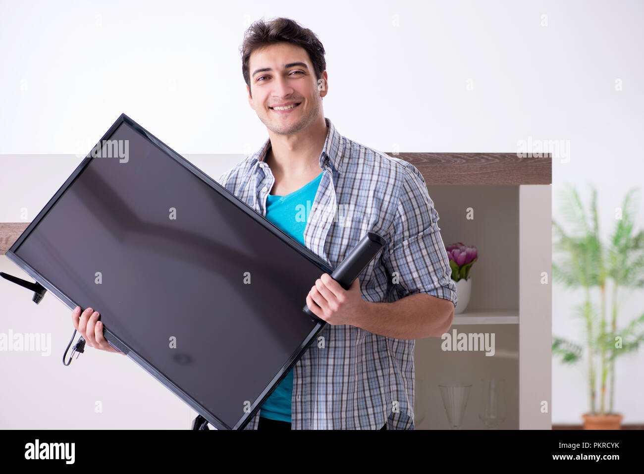 Man trying to fix broken tv Stock Photo - Alamy