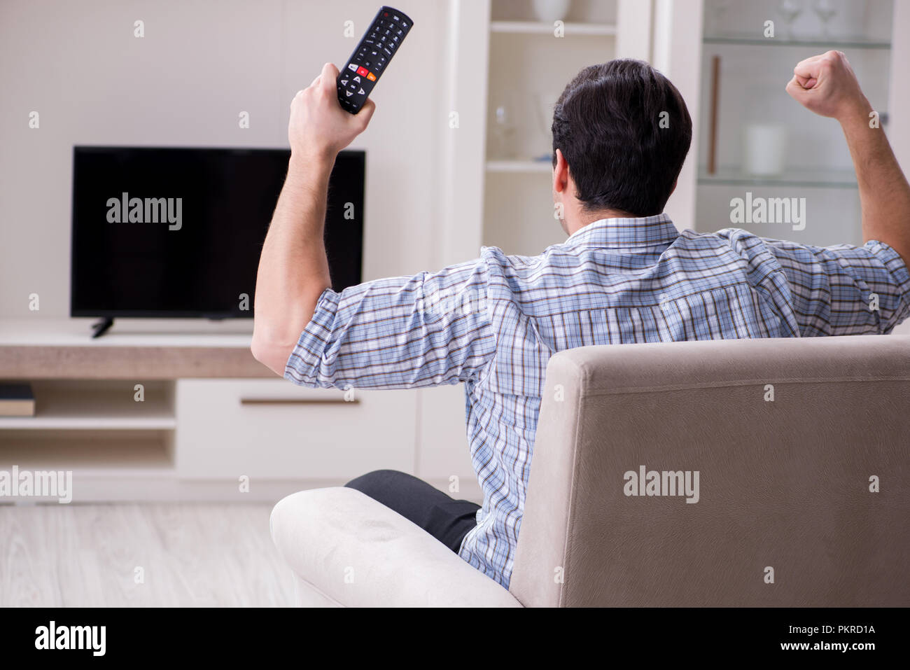Young man watching tv at home Stock Photo - Alamy