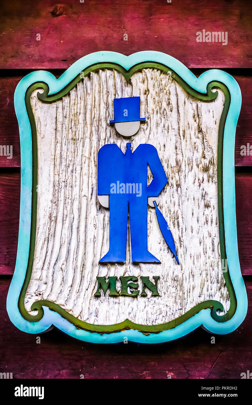Old wooden sign board with a blue man put on hat and umbrella. The word ...