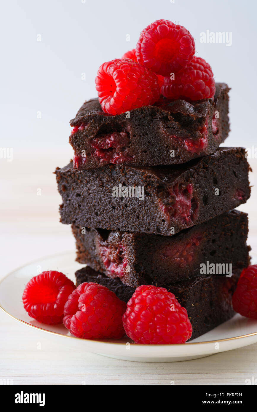 Raspberry brownies stack on a white porcelain plate with gold rim and ...