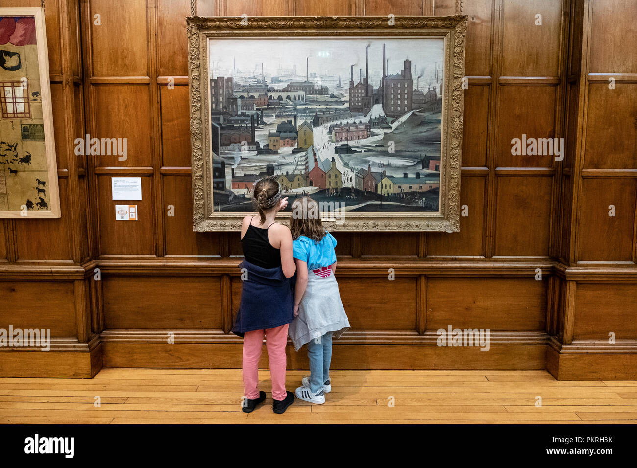 Two girls admiring a Lowry painting, inside Cartwright Hall art gallery ...