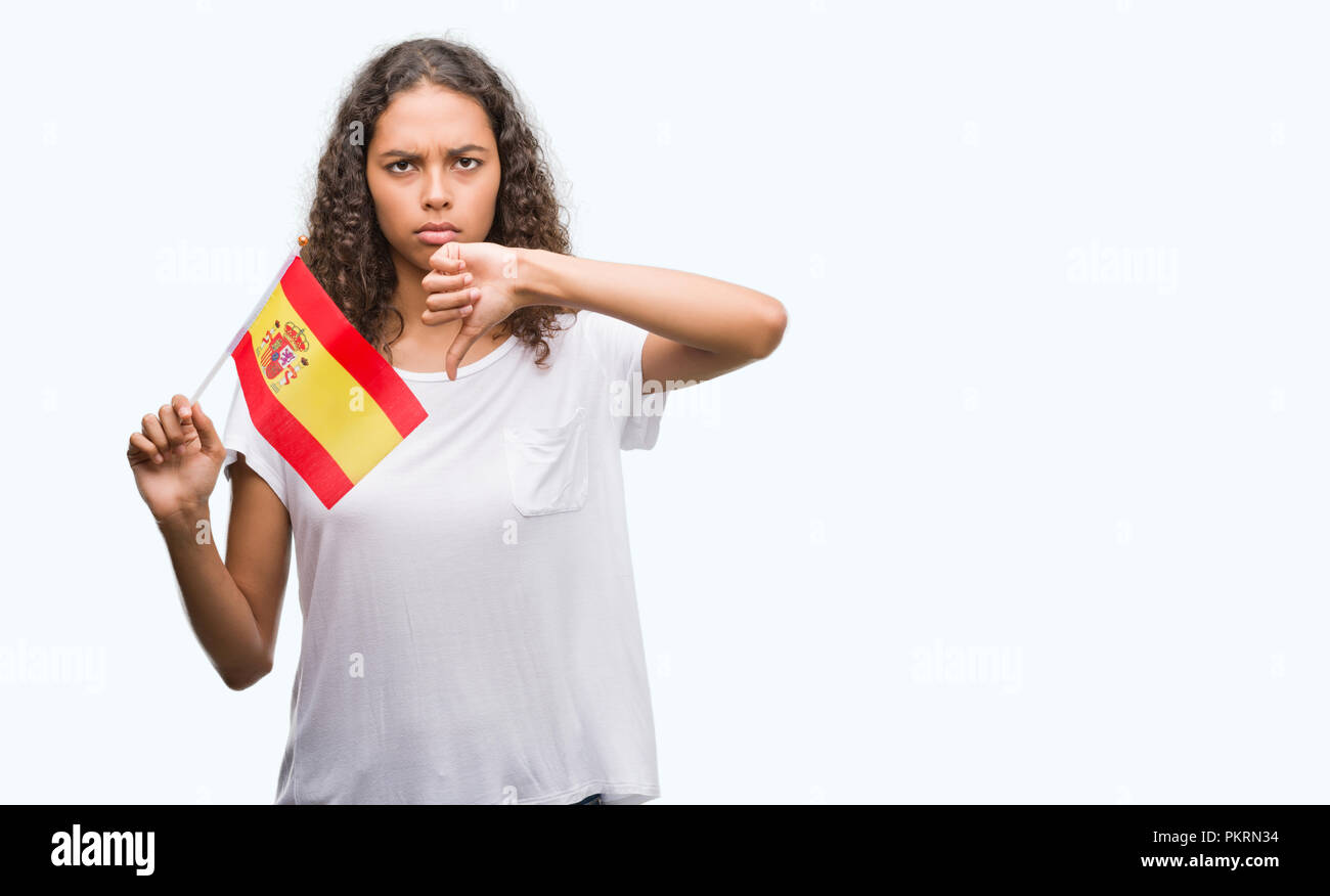 Young hispanic woman holding flag of Spain with angry face, negative ...