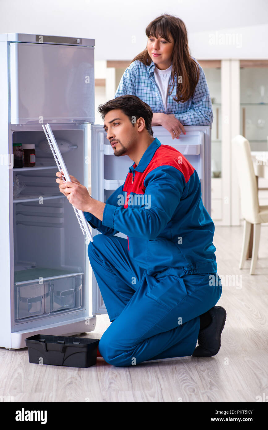 Man repairing fridge with customer Stock Photo - Alamy