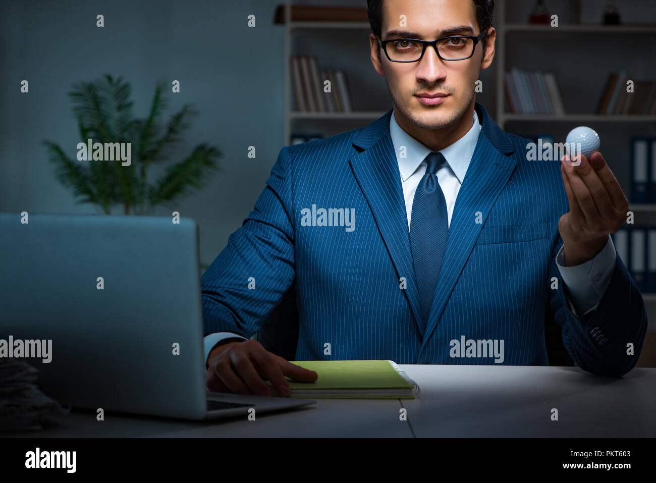 Young employee with golf ball in office Stock Photo - Alamy
