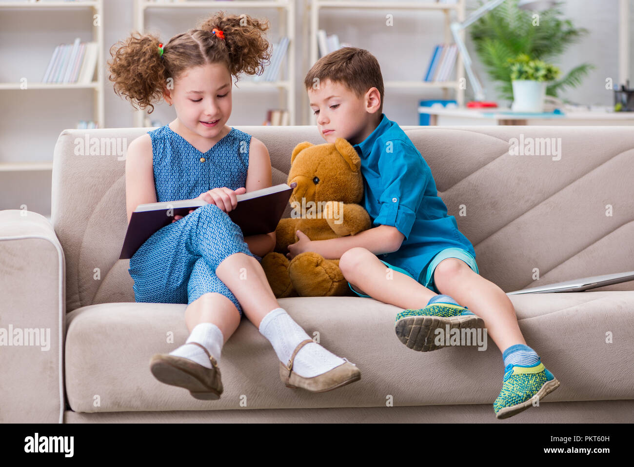 Two kids reading books at home Stock Photo - Alamy