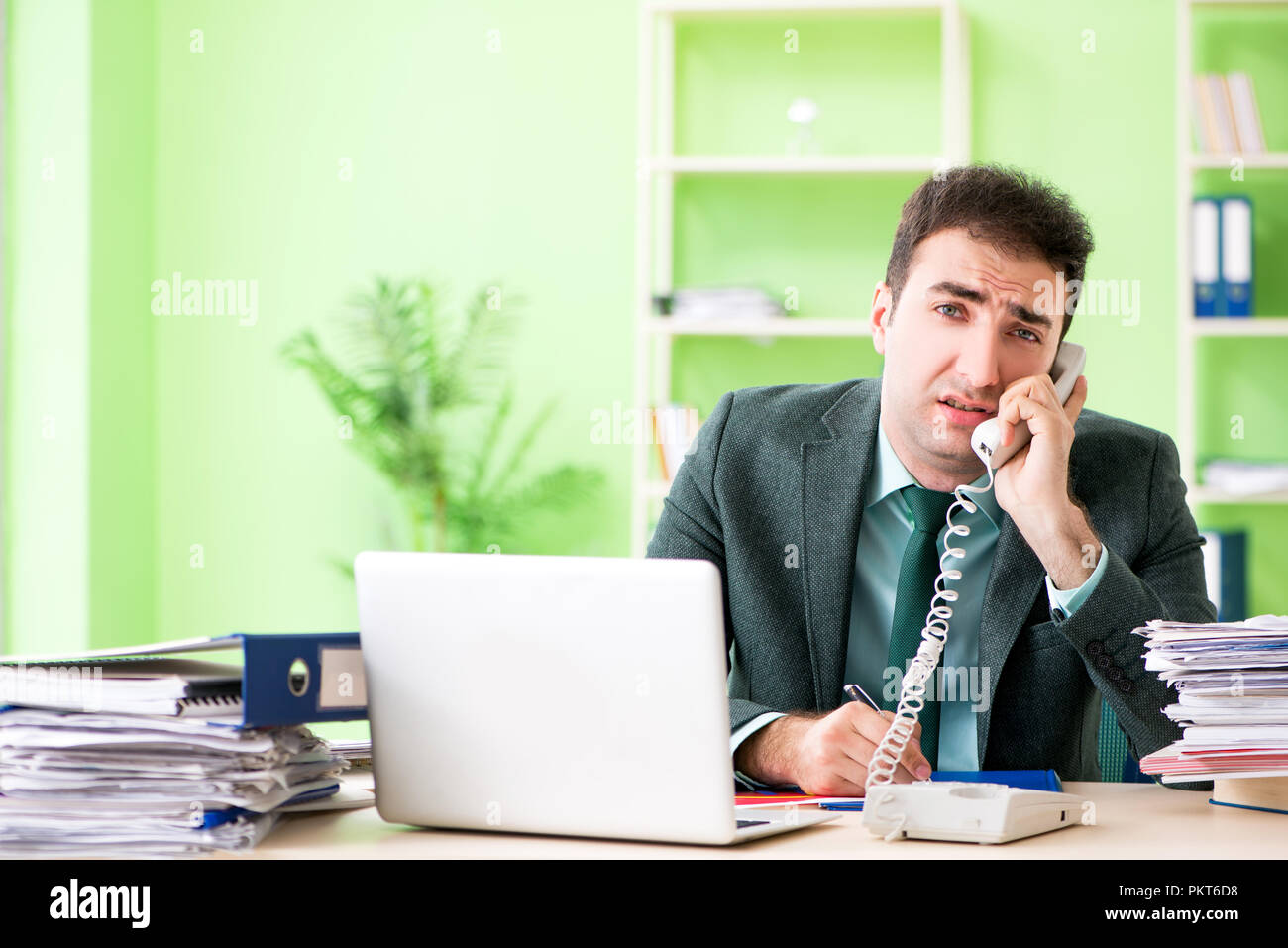 Businessman angry with excessive work sitting in the office Stock Photo ...