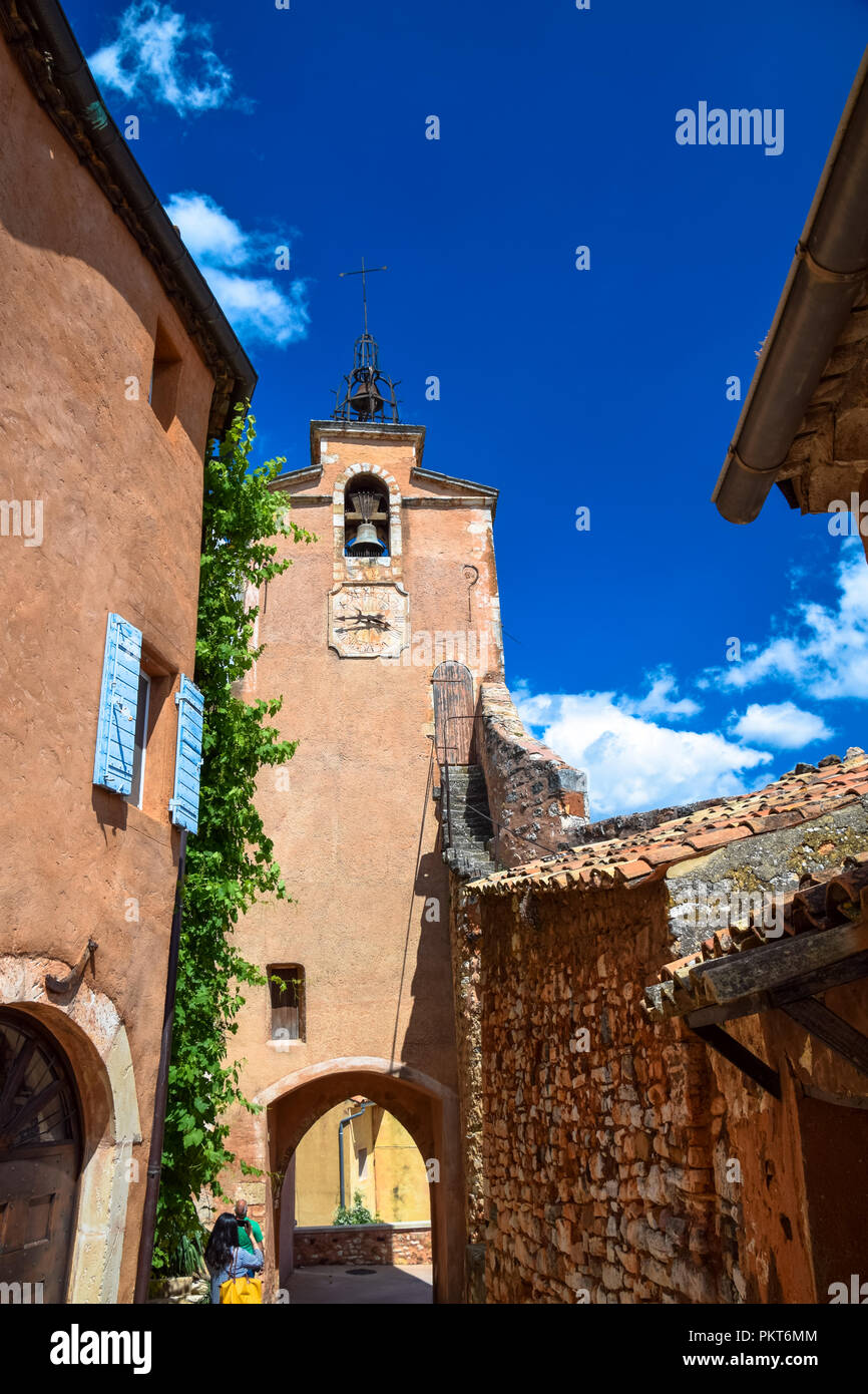 The main bell and clock tower in the center of the ochre-colored ...