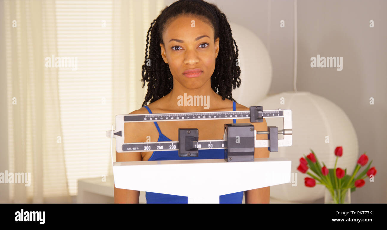 Disappointed black woman checks weight and walks away Stock Photo - Alamy